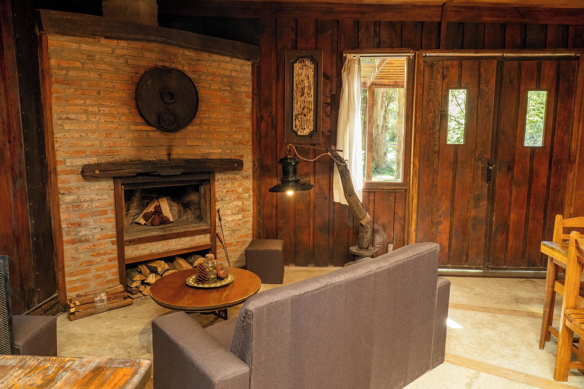Um interior rústico com lareira de tijolos, porta de madeira e um espaço de estar aconchegante.