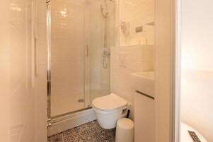 Um secador de cabelo, toalhas fornecidas, papel higiénico 