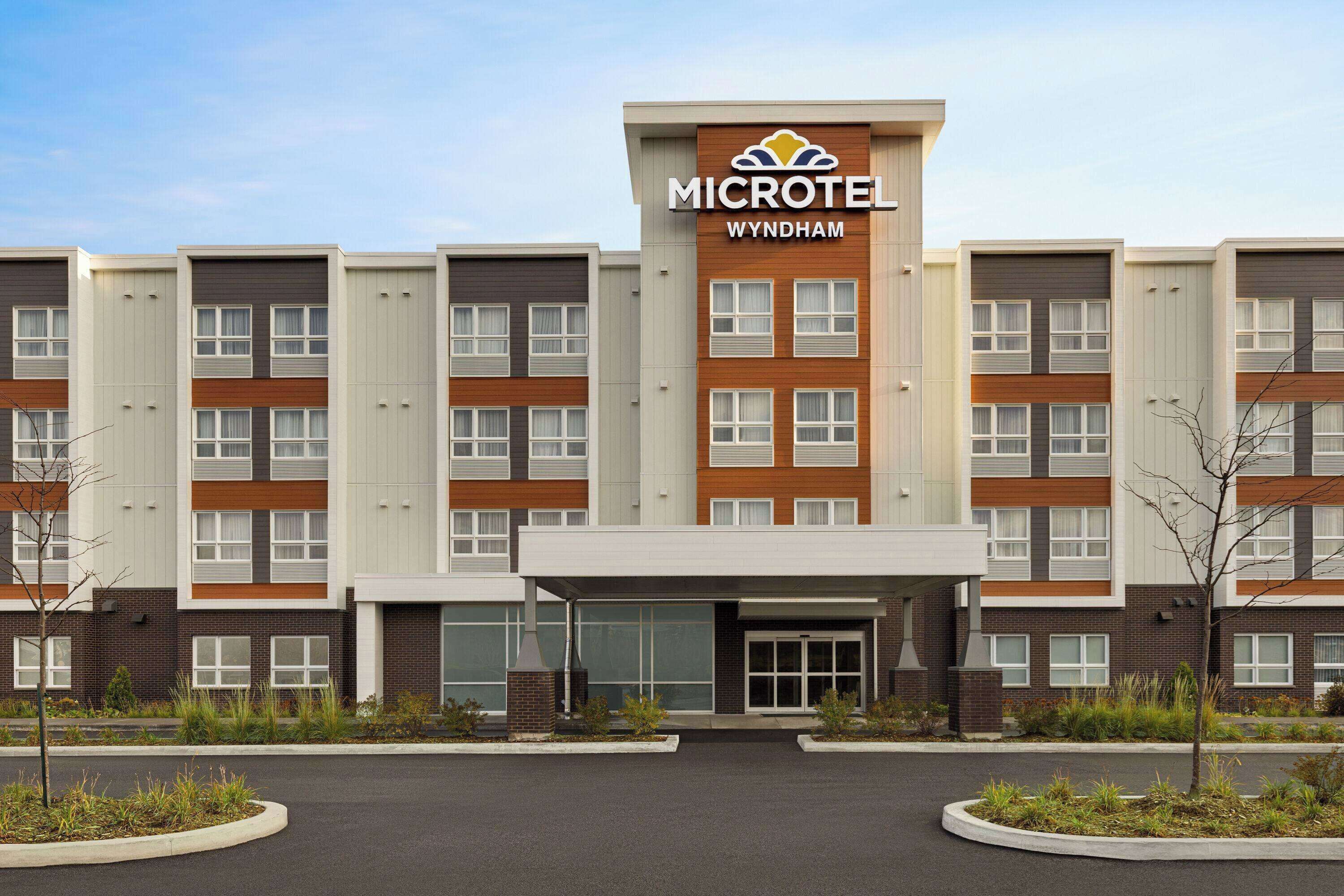 Um hotel Microtel Wyndham com design moderno, com vários andares e entrada central.