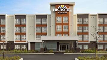 Um hotel Microtel Wyndham com design moderno, com vários andares e entrada central.