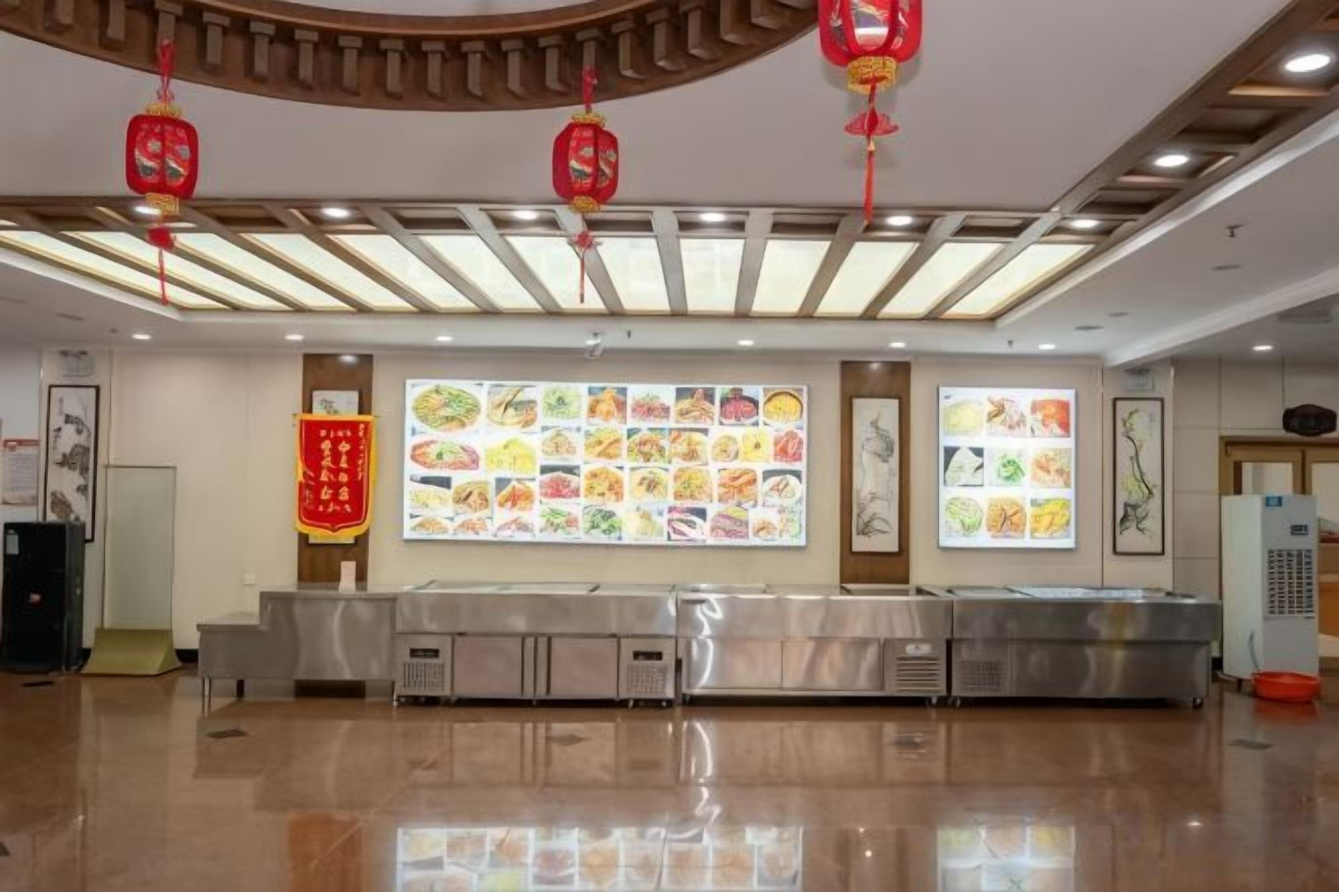 Um hall amplo com um balcão de recepção extenso, um painel de menus e piso lustroso.