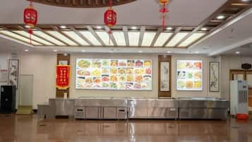 Um hall amplo com um balcão de recepção extenso, um painel de menus e piso lustroso.