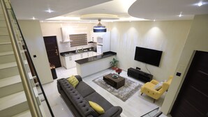 Uma sala de estar moderna com um sofá, mesa de centro e televisão na parede.