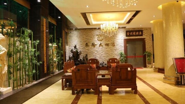 Um hall com uma mesa redonda de madeira e cadeiras, um candelabro e uma parede de pedra com uma placa.