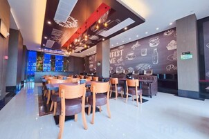 Um restaurante moderno com área de bar, mesas e cadeiras de madeira.