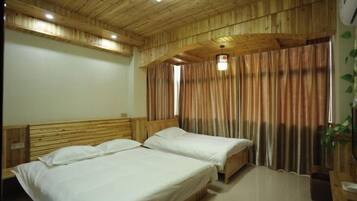 Quarto com duas camas de madeira, teto de madeira e janela com cortinas.