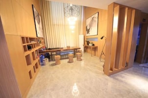 Um interior moderno com piso de mármore, móveis de madeira e uma grande janela com cortinas.