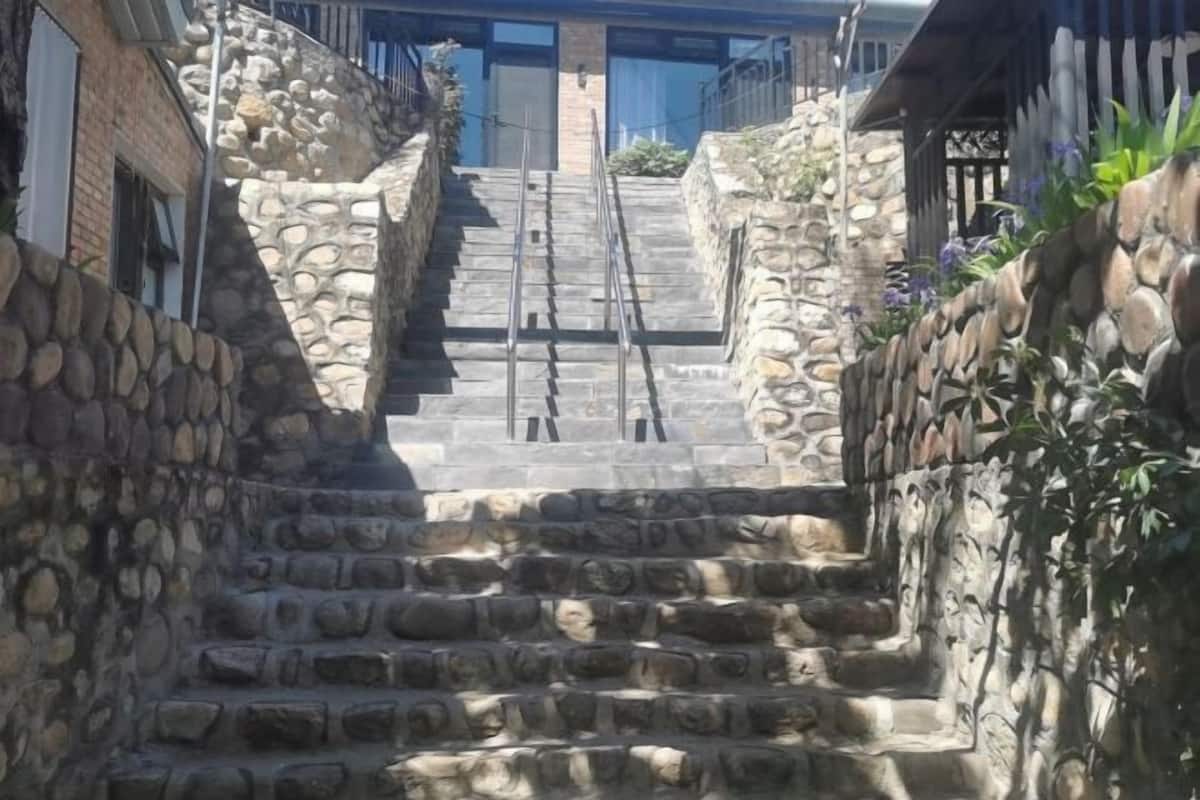 Uma escadaria de pedra que leva a um edifício com uma porta de vidro no topo.