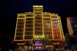 Um hotel com vários andares, sinalização iluminada e entrada destacada.