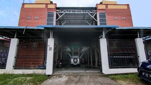 Um edifício com entrada coberta e um veículo no interior.