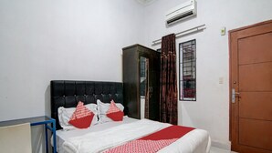 Quarto com uma cama, guarda-roupa, escrivaninha e porta.