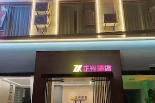 Entrada de hotel com letreiro de neon, aparelhos de ar condicionado e design de interiores moderno.