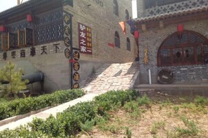 Um edifício tradicional com escadaria de pedra, um canhão e uma placa com caracteres chineses.