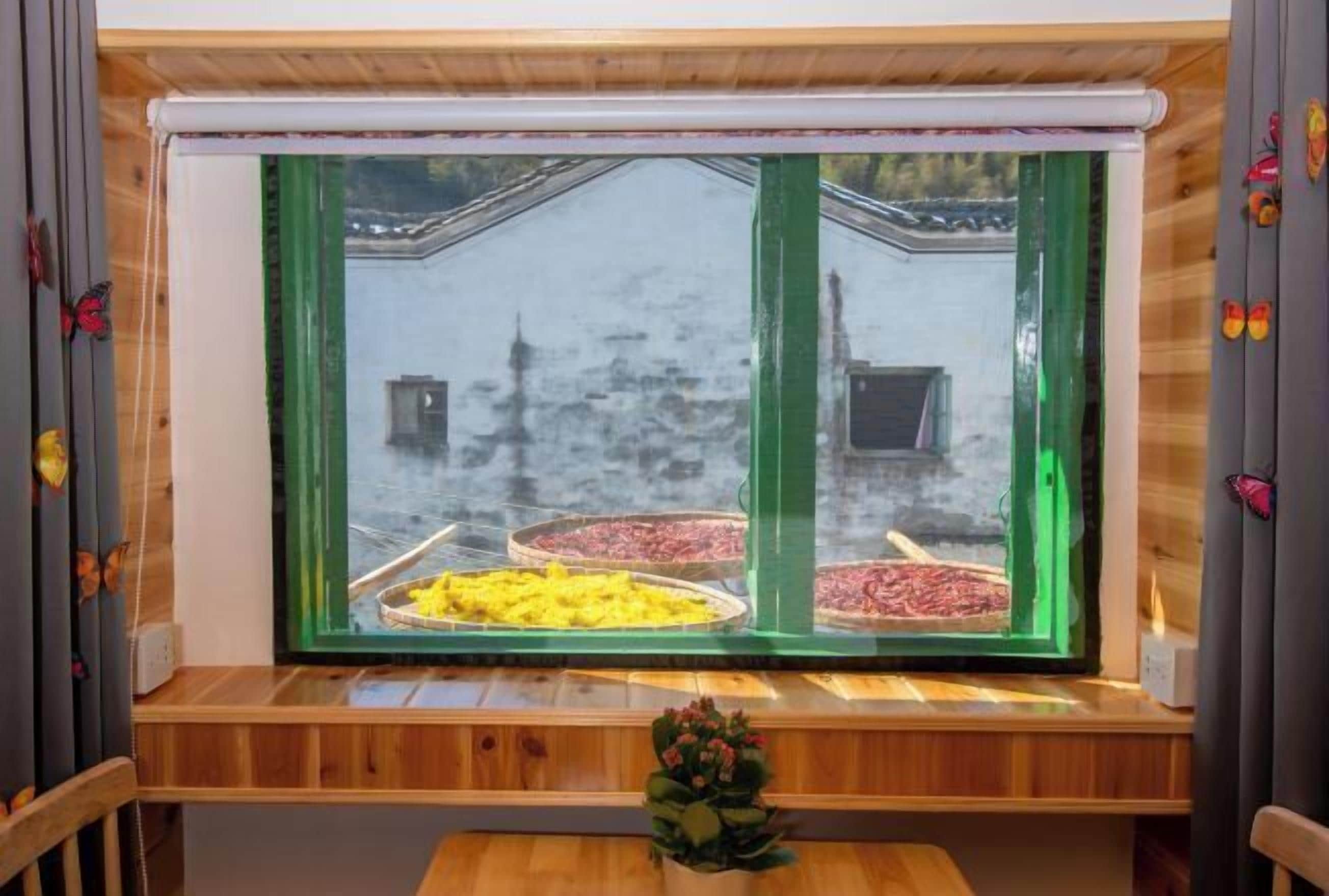 Janela com vista para uma ponte e uma mesa de buffet com diversos alimentos.