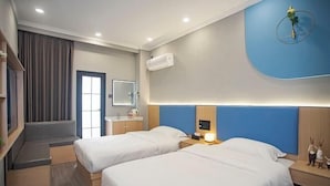 Quarto de hotel com duas camas, banheiro, espelho e escada.