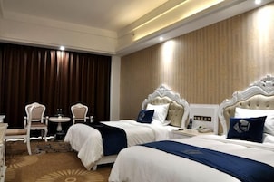 Quarto de hotel com duas camas, uma mesinha com cadeiras e uma janela grande com cortinas.