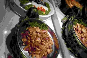 Uma mesa de jantar com diversos pratos, incluindo uma salada, um prato de carne e uma sopa.