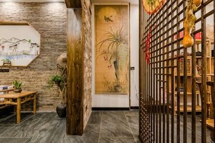 Um interior tradicional com porta de madeira, quadro emoldurado e um banco de madeira.