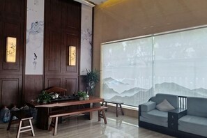 Um quarto com uma mesa de madeira, um sofá e uma grande janela com vista para as montanhas.