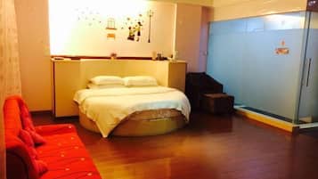 Um quarto com cama, sofá vermelho, guarda-roupa e uma parede com elementos decorativos.