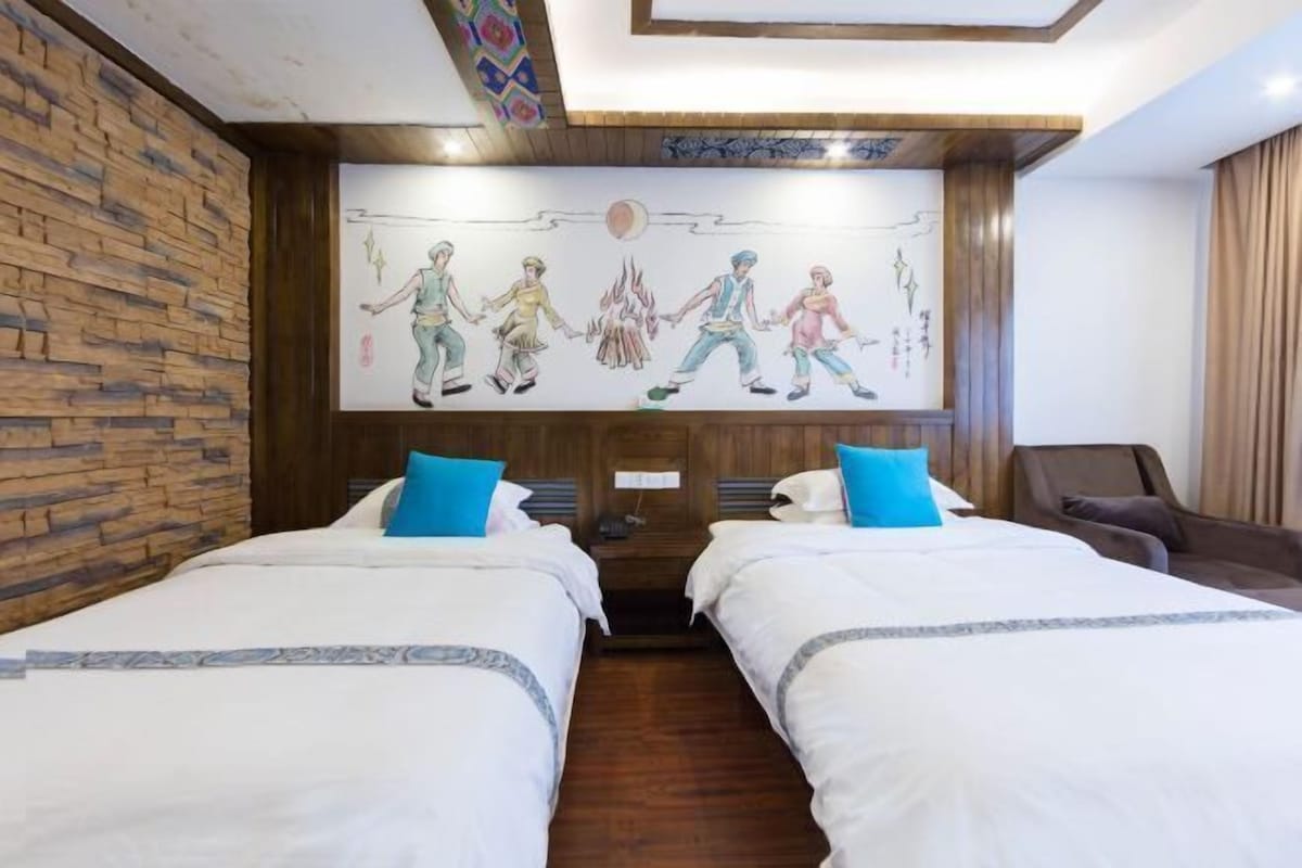 Quarto de hotel com duas camas, um mural na parede e painéis de madeira.