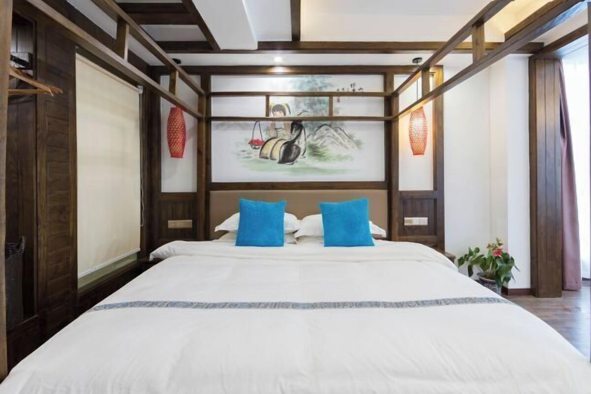 Quarto com cama grande, cabeceira de madeira e obra de arte na parede.