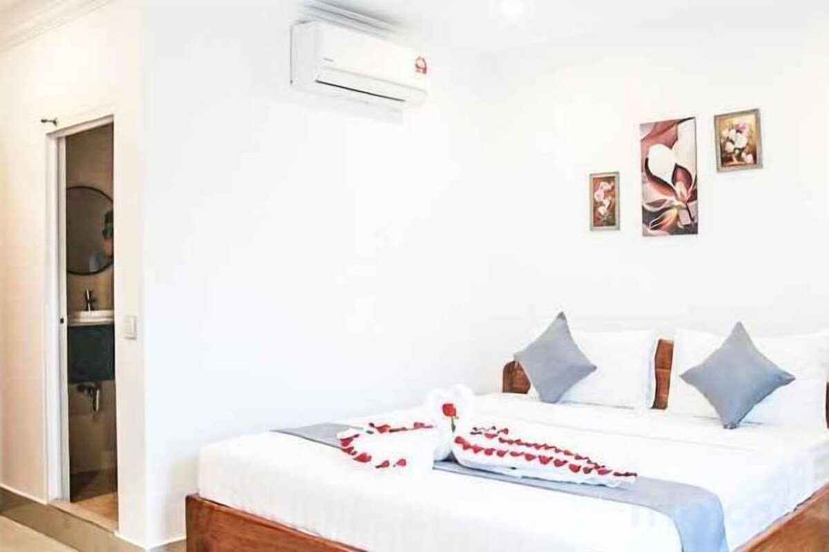 Quarto de hotel com cama, porta e unidade de ar condicionado na parede.