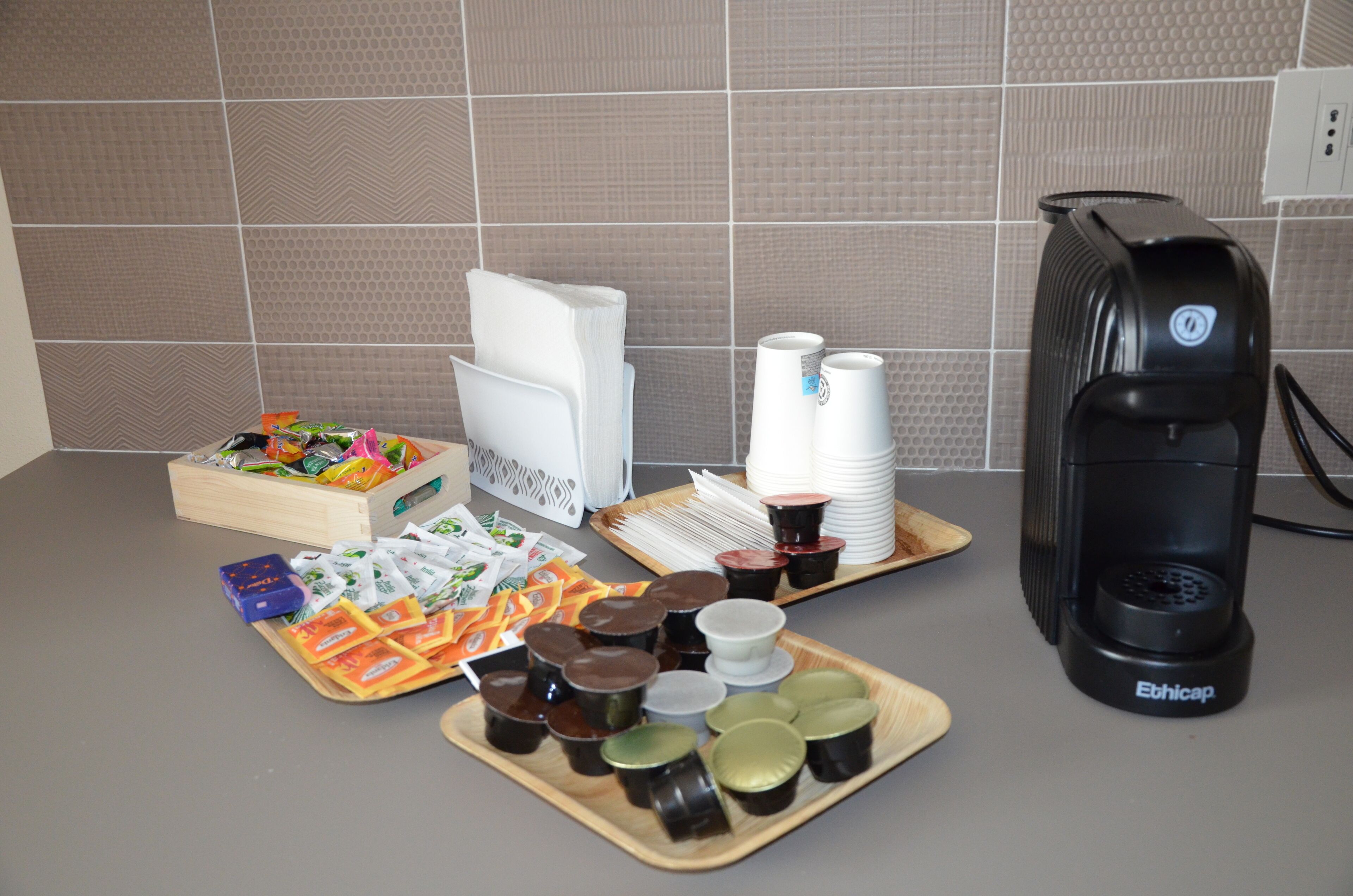 Um espaço com café, incluindo cafeteira, xícaras e diversos alimentos sobre um balcão.
