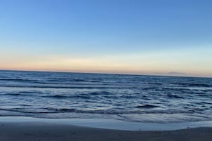 Uma praia com ondas e céu claro.