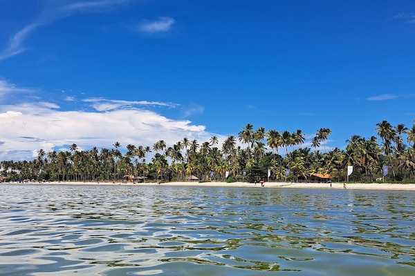 Na praia, praia de areia branca, espreguiçadeiras, guarda-sóis de praia