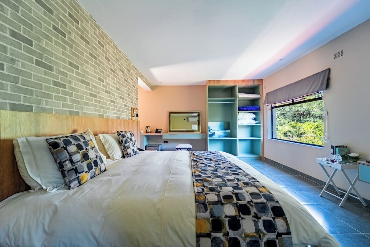 Quarto Deluxe, vista para o jardim | Secretária, secretária adequada para computadores portáteis