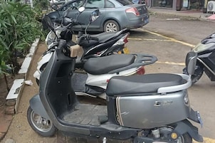 Uma scooter estacionada com logotipo da marca visível na lateral.
