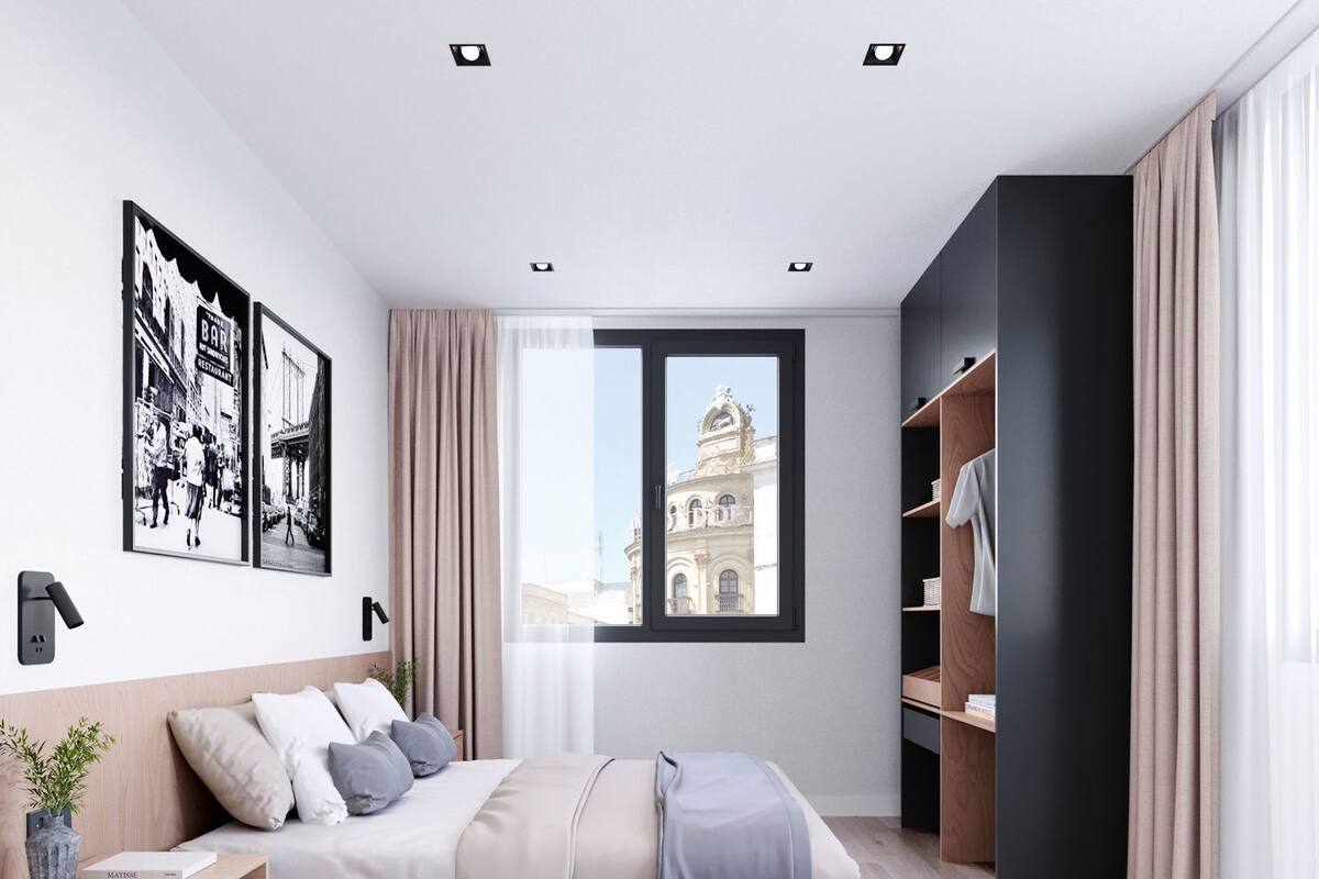Quarto moderno com cama, mesa de cabeceira e vista para um edifício histórico.