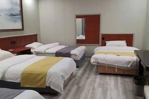 Quarto de hotel com duas camas, uma cabeceira de madeira, uma mesinha de cabeceira, um espelho e um quadro na parede.