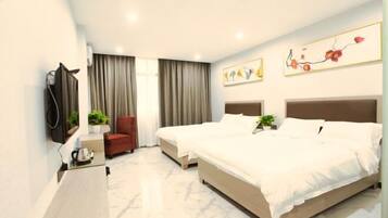 Quarto de hotel com duas camas, uma escrivaninha, uma cadeira, uma televisão e obras de arte nas paredes.