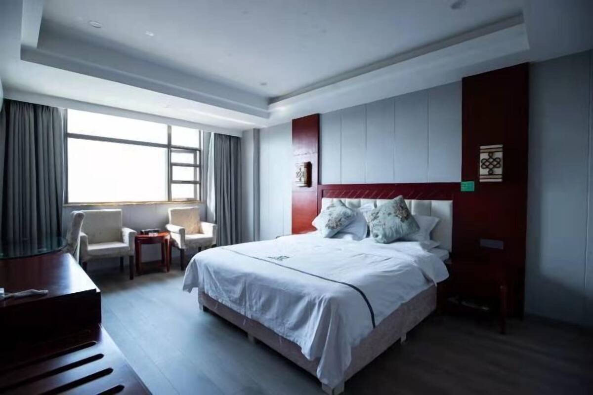 Quarto de hotel moderno com uma cama grande, uma escrivaninha e uma cadeira.