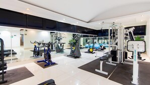 Uma academia moderna com diversos equipamentos de exercícios, incluindo esteiras, bicicletas ergométricas e aparelhos de musculação.
