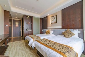 Quarto de hotel com duas camas, uma grande obra de arte na parede e design em painel de madeira.