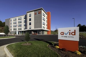 Um edifício moderno com uma placa indicando 'Avid An IHG Hotel', identificando o local como um hotel.