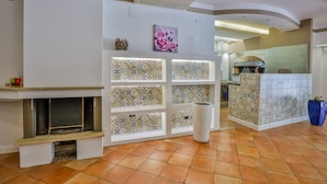 Uma cozinha moderna com forno embutido, um vaso branco grande e uma parede decorativa com azulejos.