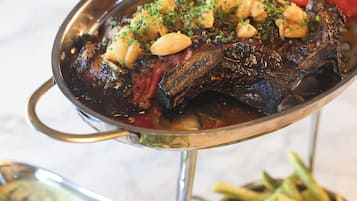 Prato de carne grelhada com legumes e batatas fritas.