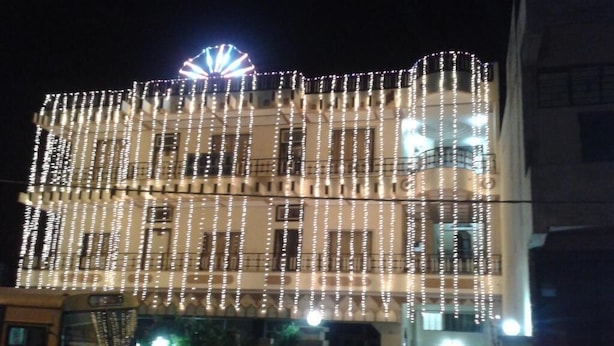 Um edifício com várias andares, varandas e luzes de Natal.