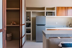 Um frigorífico/congelador grande, um micro-ondas, uma placa de cozinha 