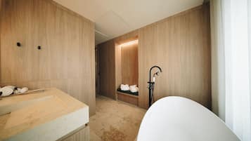 Uma casa de banho moderna com toucador de madeira, banheira e zona de duche.