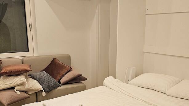 Quarto com uma cama grande, um sofá e uma janela.