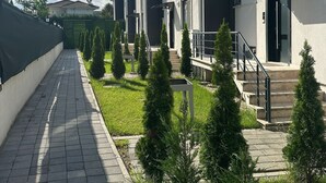 Uma fileira de edifícios modernos com um calçadão e pequenas árvores.