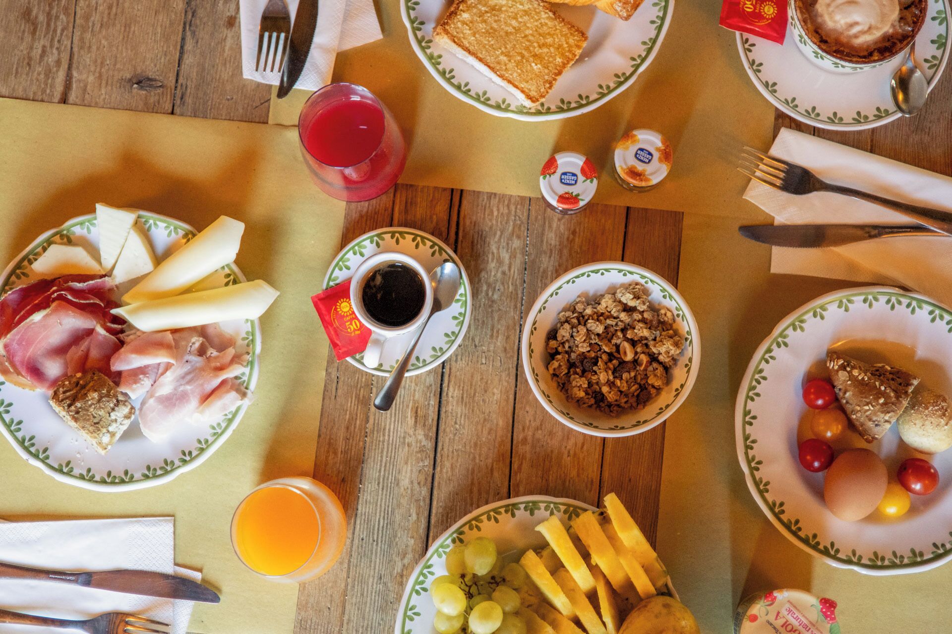 Uma mesa de café da manhã com pratos de comida, incluindo torradas, frutas e ovos.