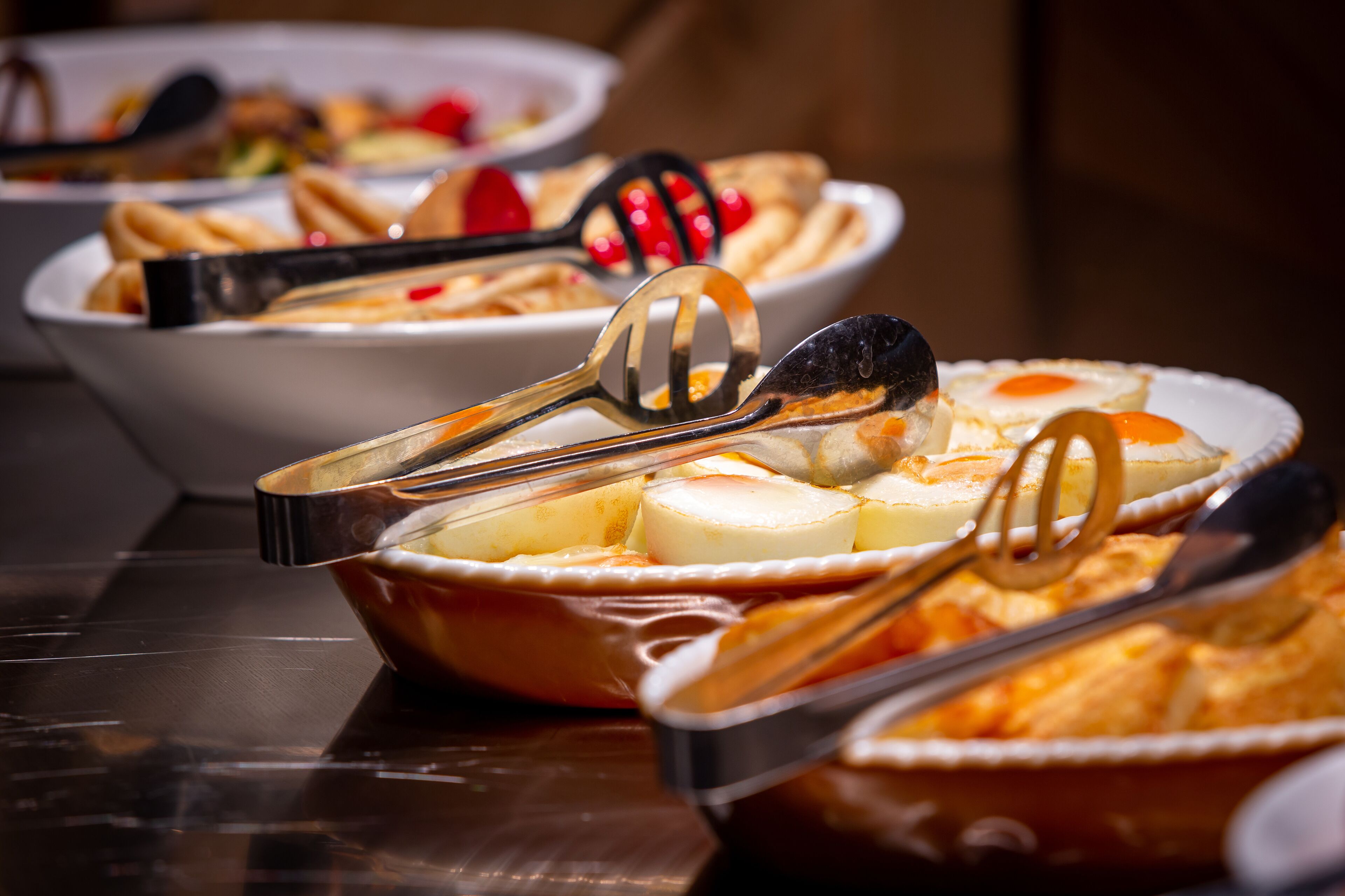 Uma mesa de buffet com diversos pratos e utensílios.
