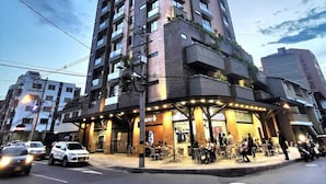 Edifício de vários andares com restaurante no térreo e área externa para clientes.