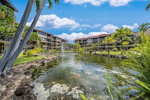Um hotel com vários andares, um elemento central de água e vegetação exuberante.